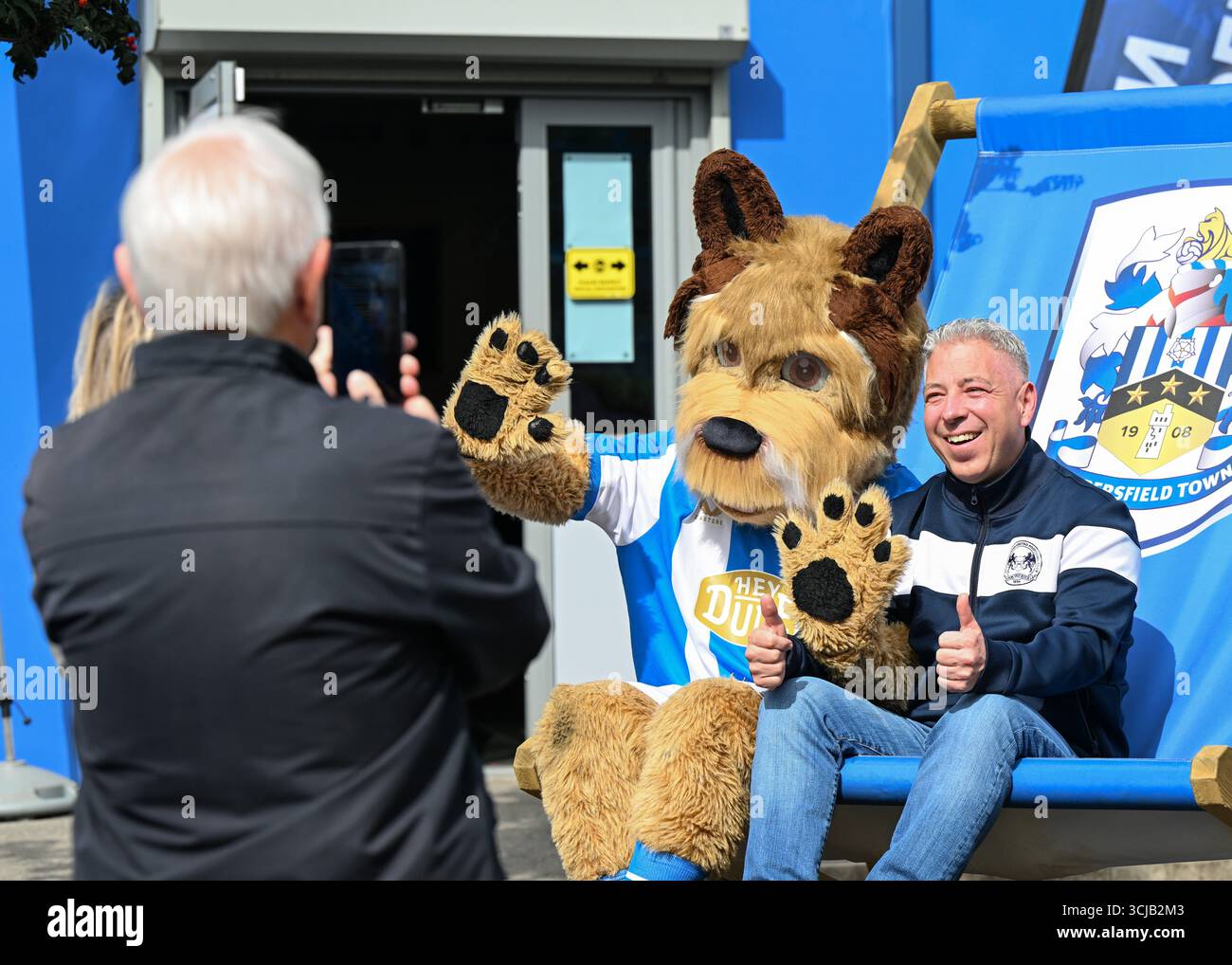 A Peterborough United fan poses for a photograph with Huddersfield Town ...