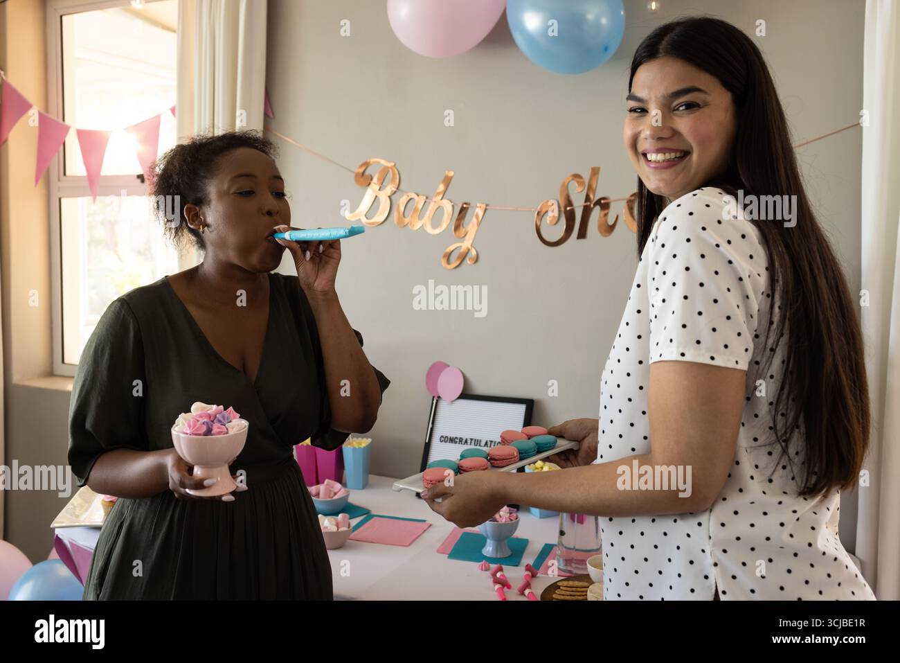 Celebrating baby shower, women enjoying desserts and decorations with ...