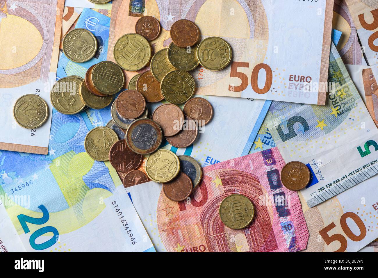 Euro banknotes and coins of different denominations used as background ...
