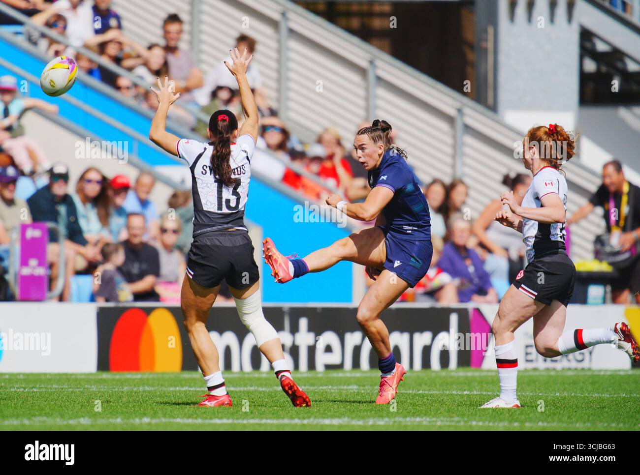 Scotland's Emma Orr (centre) kicks the ball as Canada's Florence Symonds tries to blcok it ...