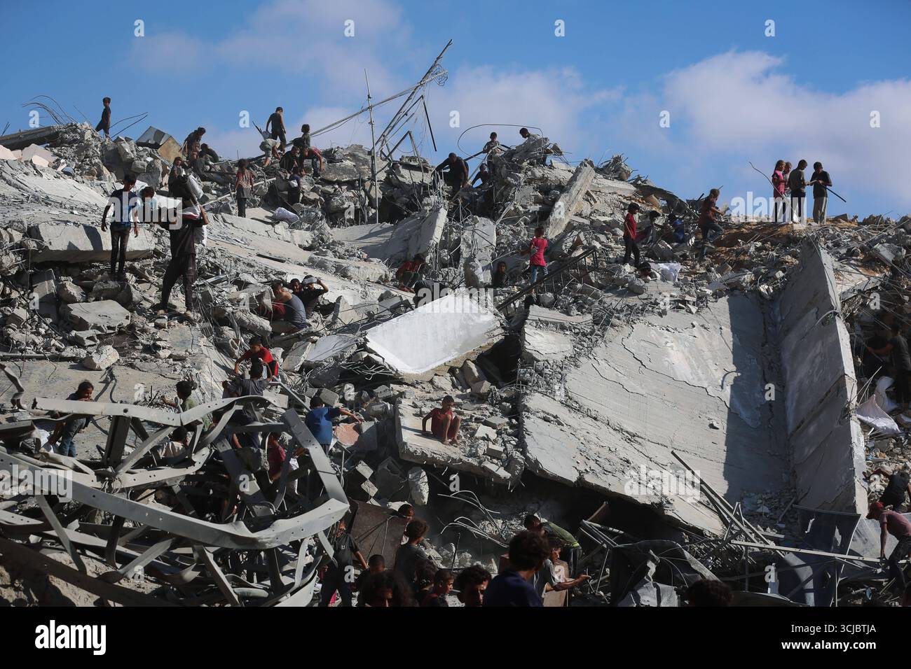 Palestinians check the debris of Al-Susi Tower in Gaza City following ...