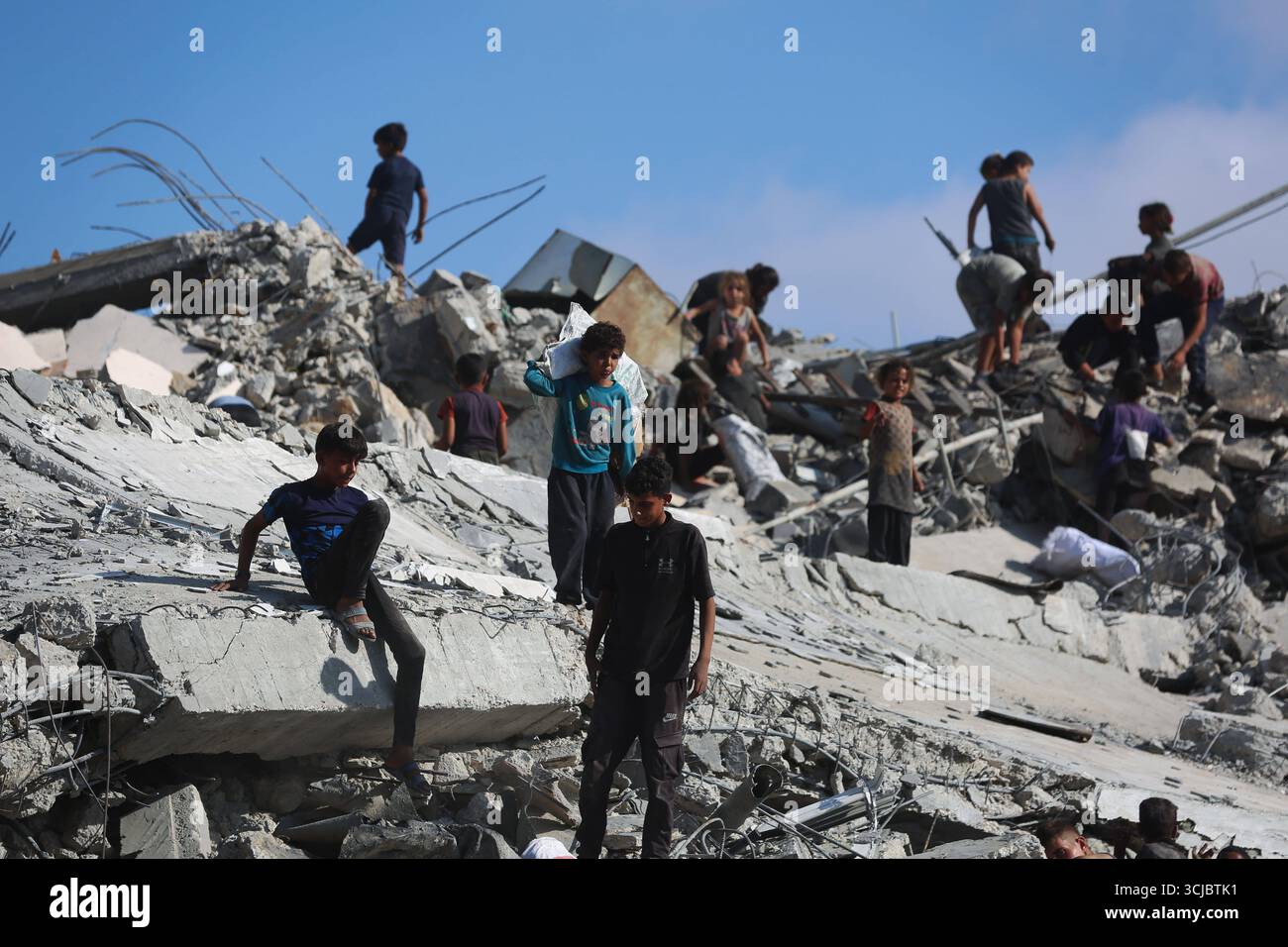 Palestinians check the debris of Al-Susi Tower in Gaza City following ...