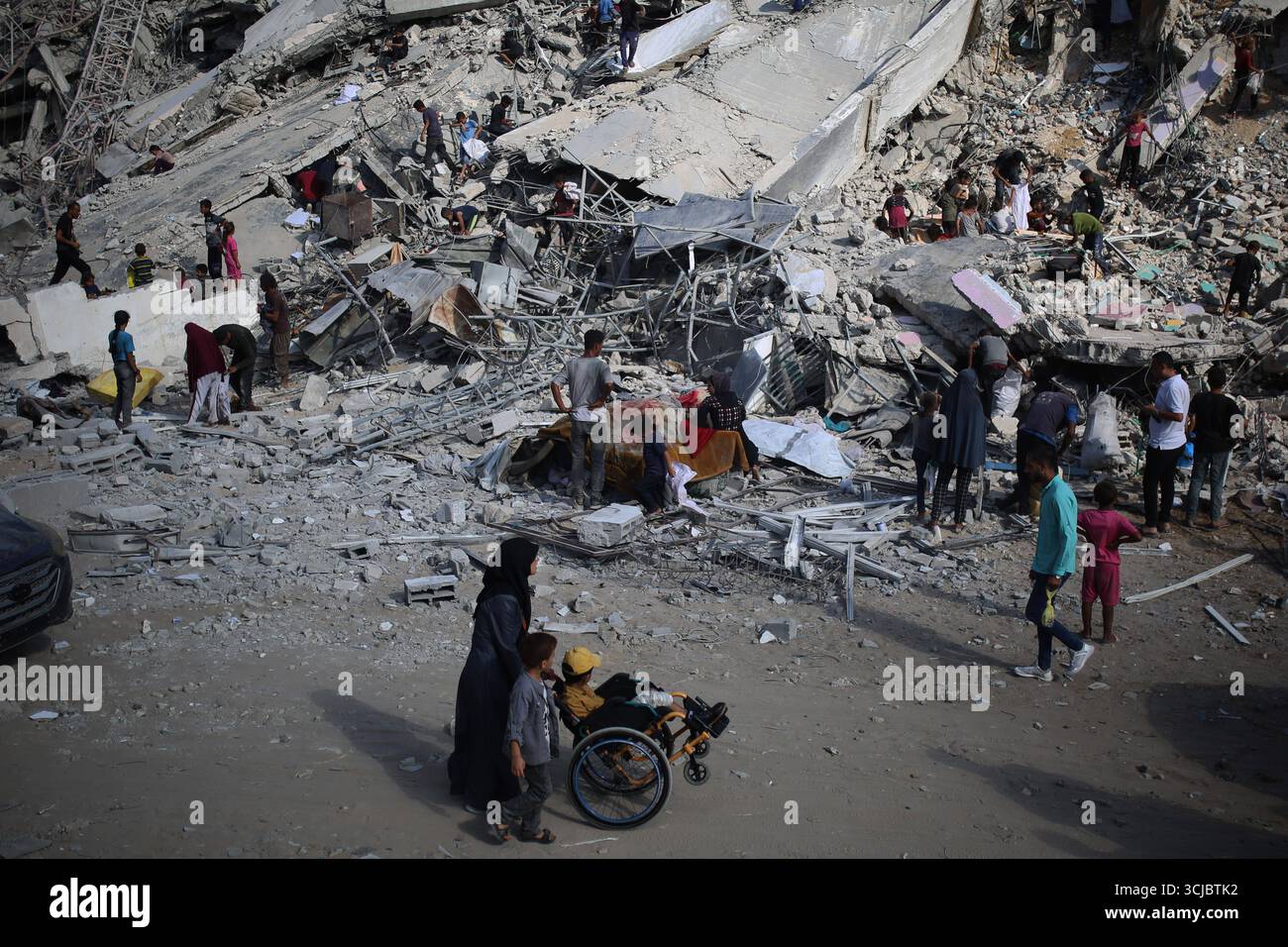 Palestinians check the debris of Al-Susi Tower in Gaza City following ...
