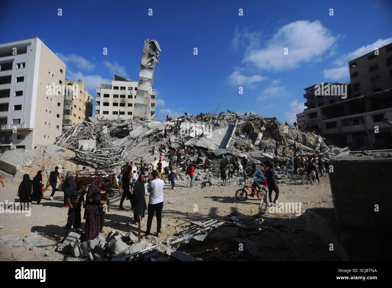 Palestinians check the debris of Al-Susi Tower in Gaza City following ...