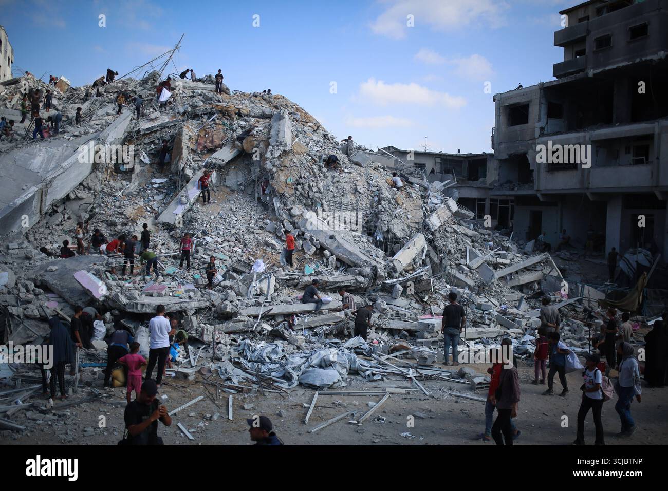 Palestinians check the debris of Al-Susi Tower in Gaza City following ...