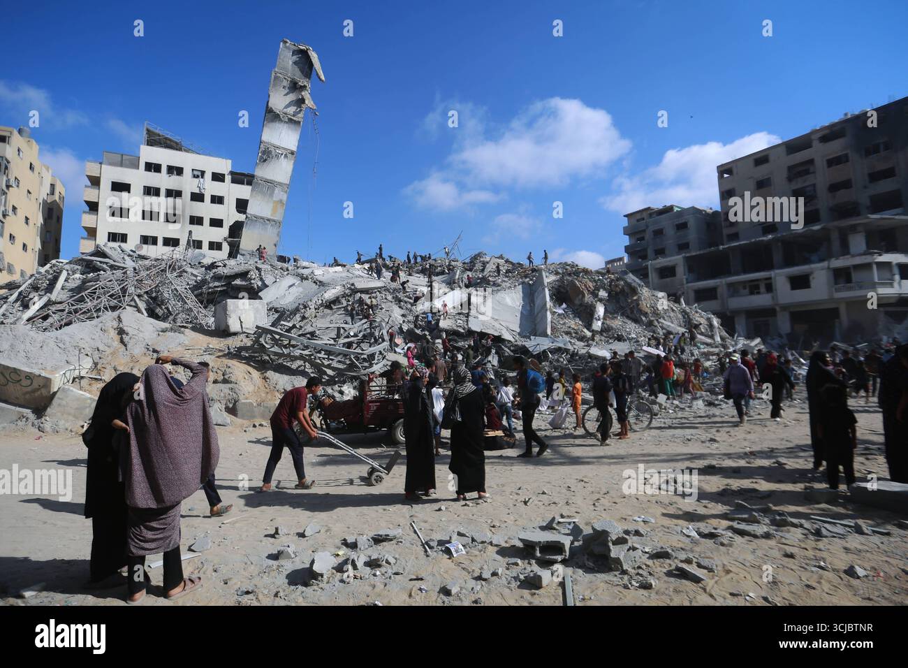 Palestinians check the debris of Al-Susi Tower in Gaza City following ...
