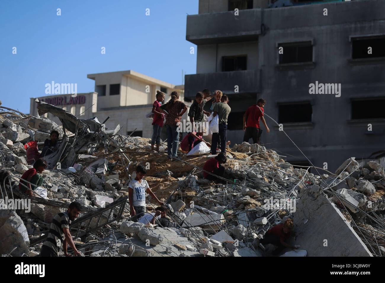 Palestinians check the debris of Al-Susi Tower in Gaza City following ...