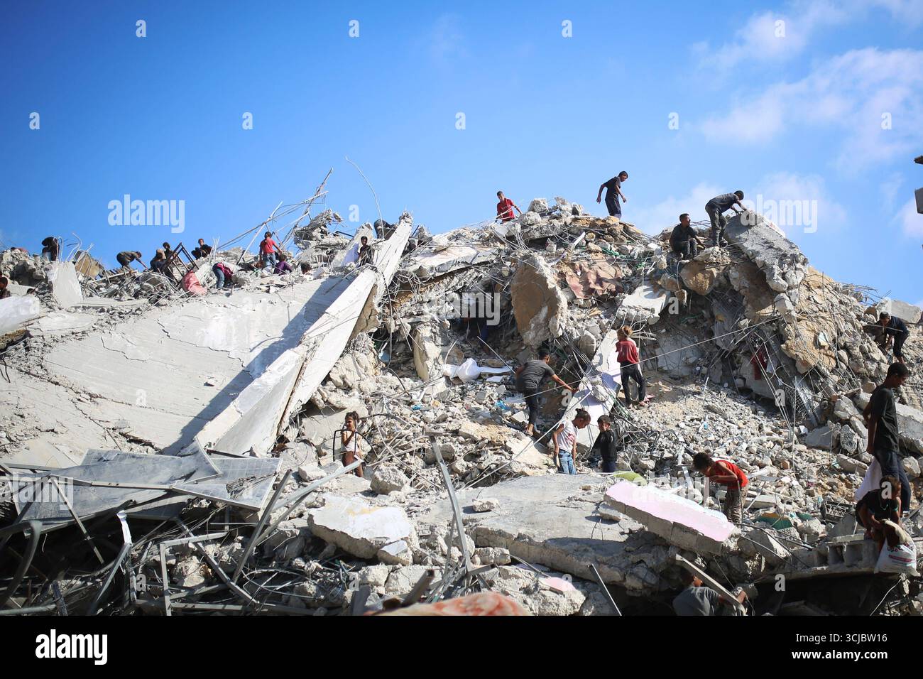 Palestinians check the debris of Al-Susi Tower in Gaza City following ...