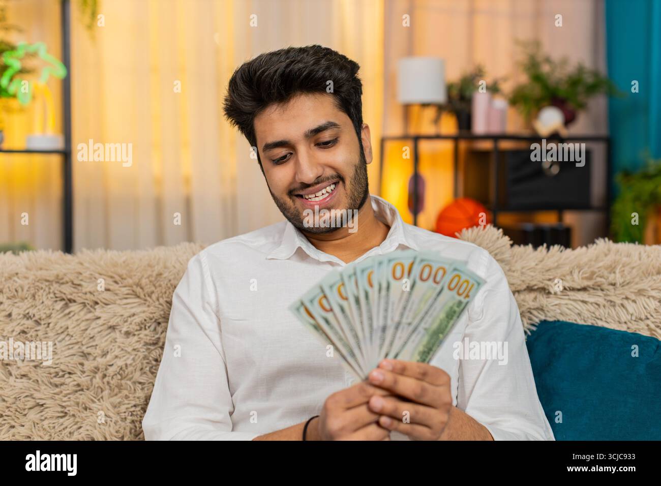 Young man is carefully counting his money hi-res stock photography and ...