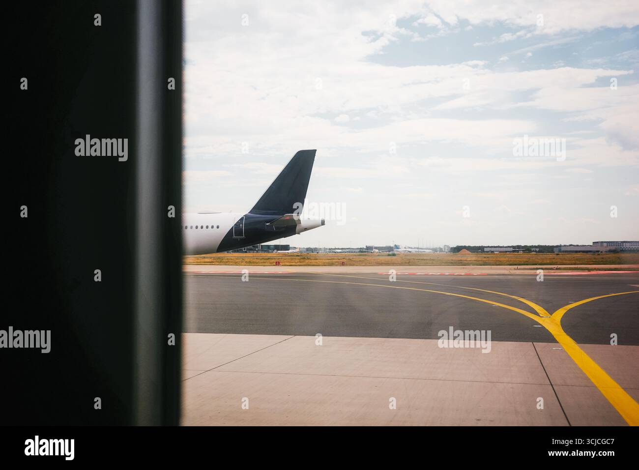 View from an airport terminal window showing the tail and wing of an ...