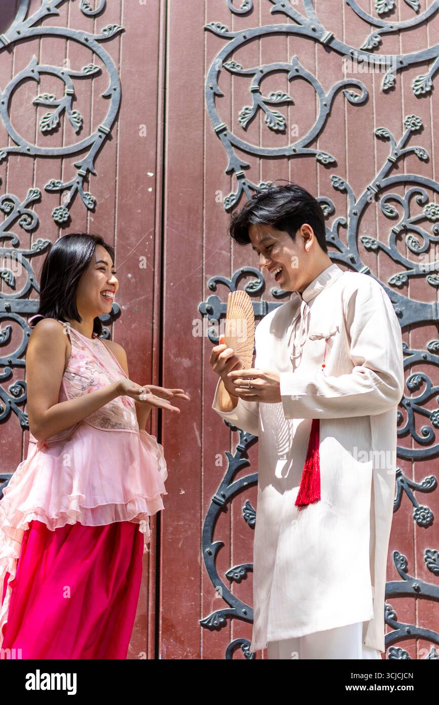 A smiling Vietnamese couple shares a joyful moment in traditional ...