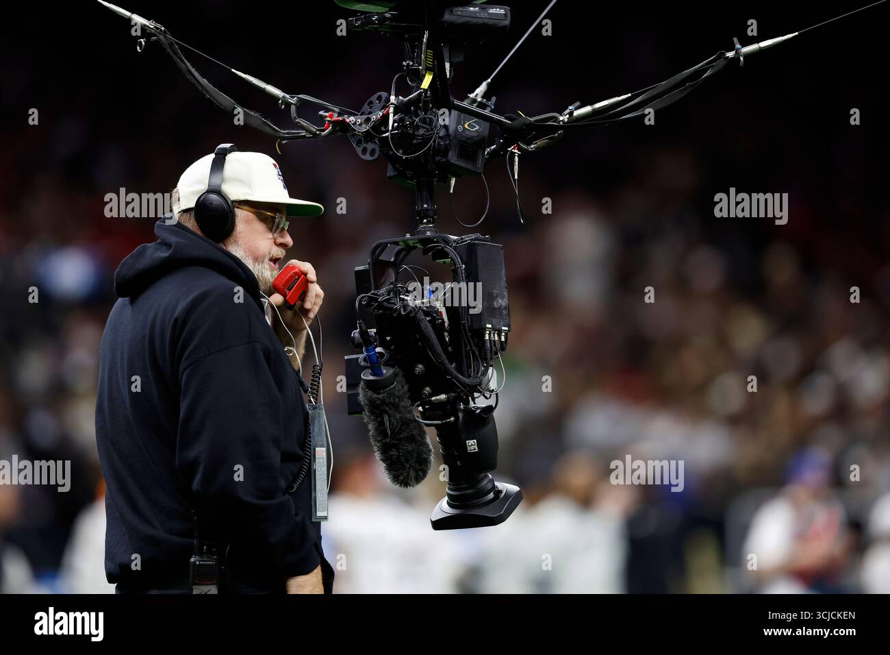 A SkyCam television technician works to repair an overhead broadcast ...