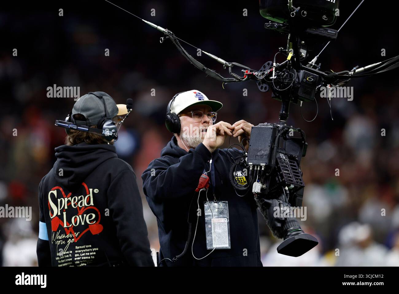 SkyCam television technicians work to repair an overhead broadcast ...