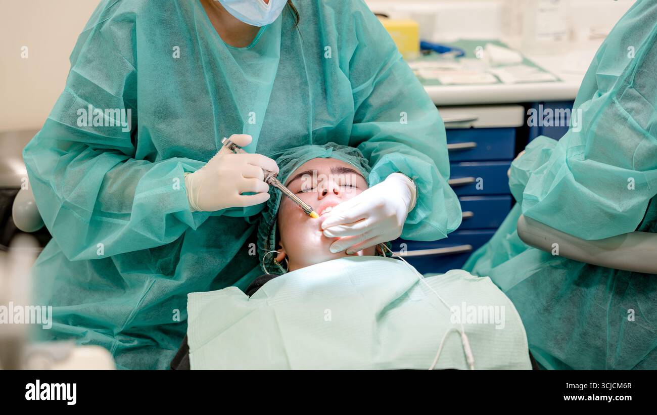 A dentist performs a dental graft procedure in a clinical setting. The ...