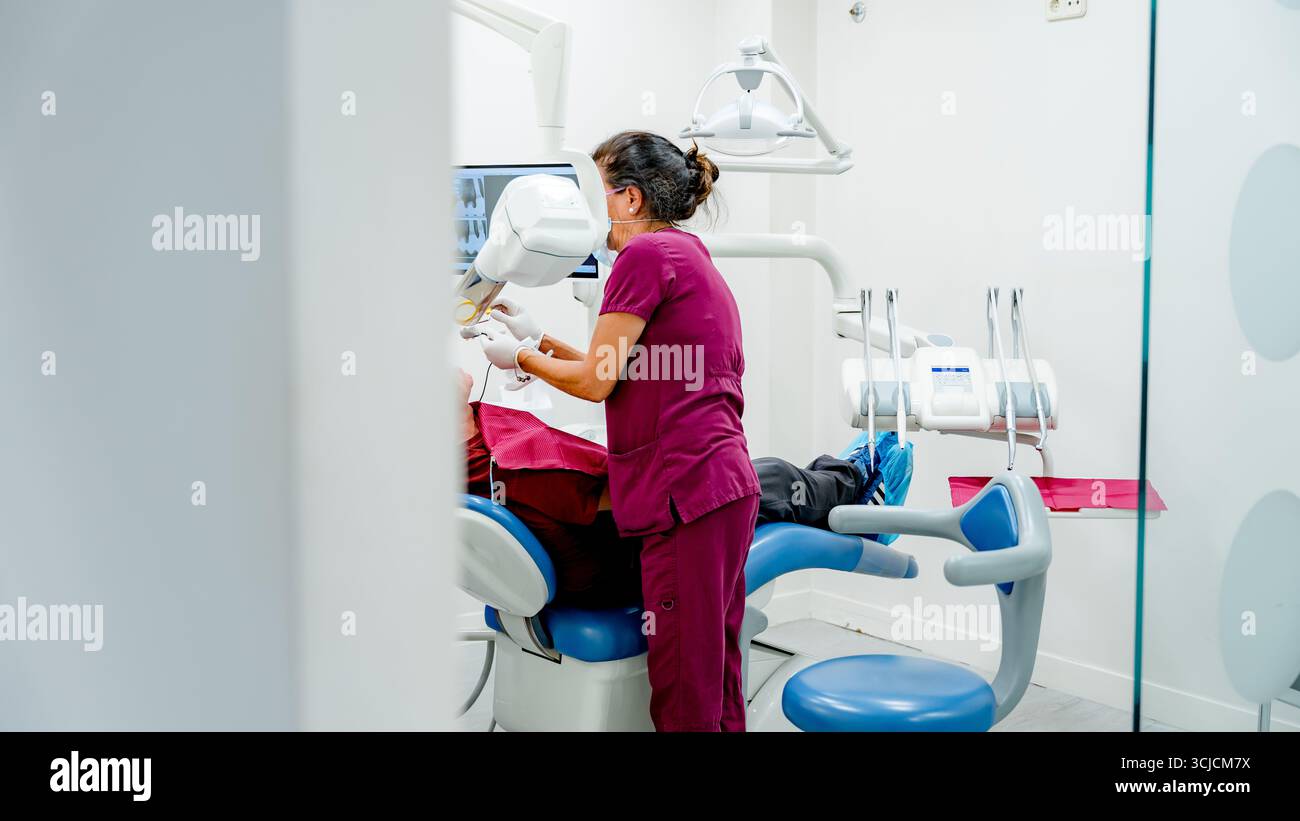 A dentist performs an implantology procedure on a patient in a modern ...