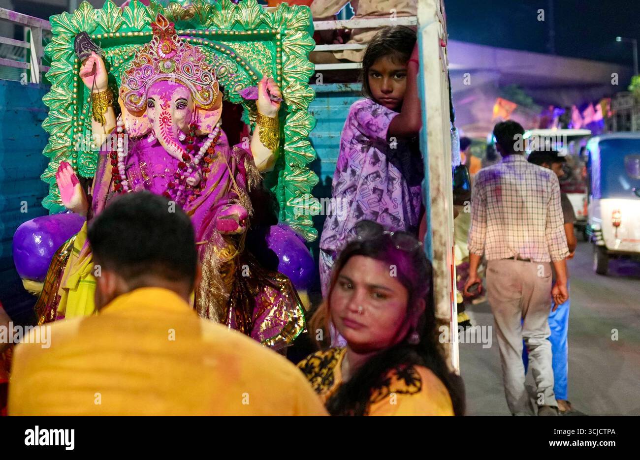 Devotees prepare to immerse an idol of the elephant-headed Hindu god, Ganesha, in the Gomati ...
