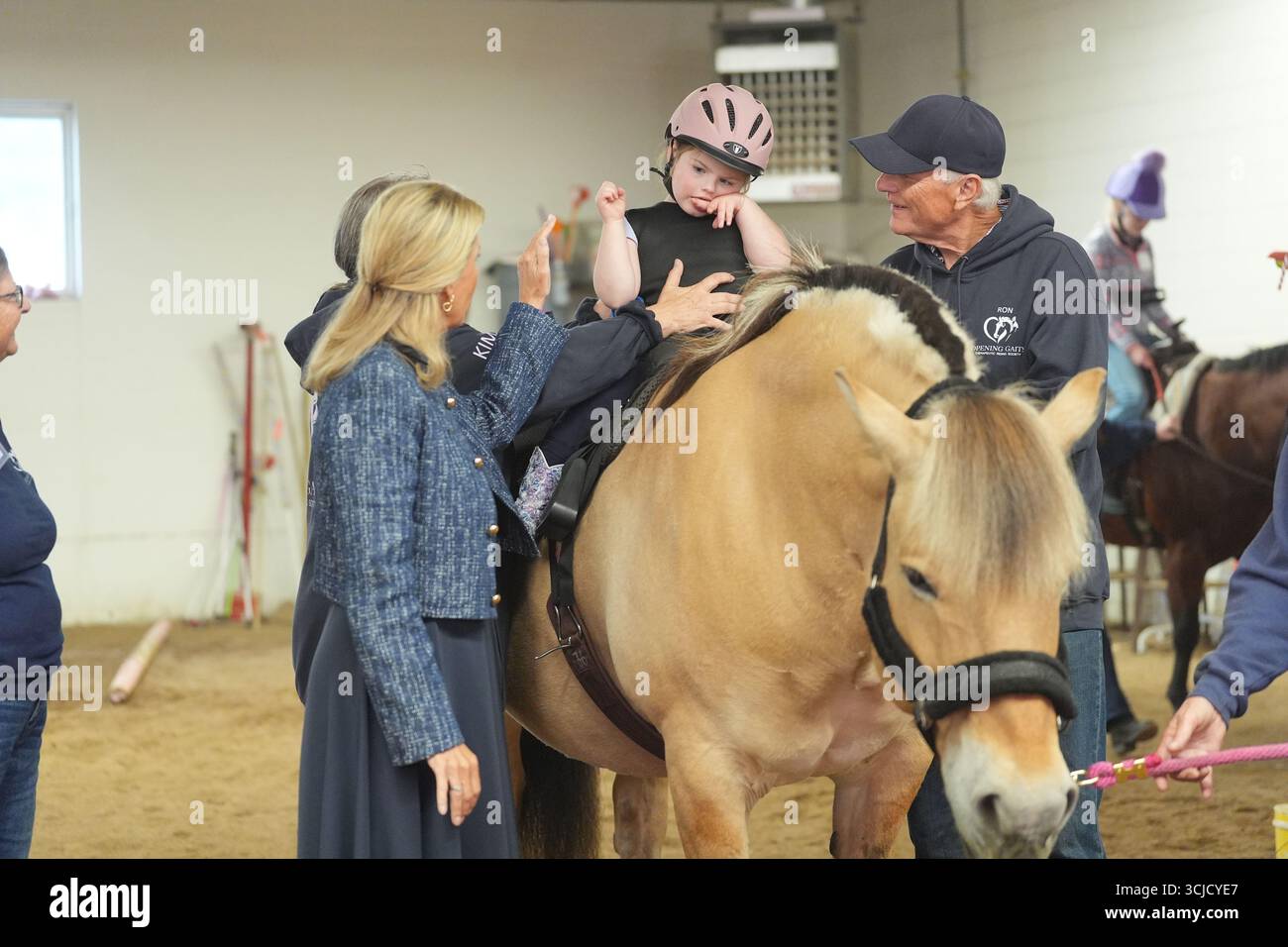 The Duchess of Edinburgh (left) interacts with a young rider, during a ...