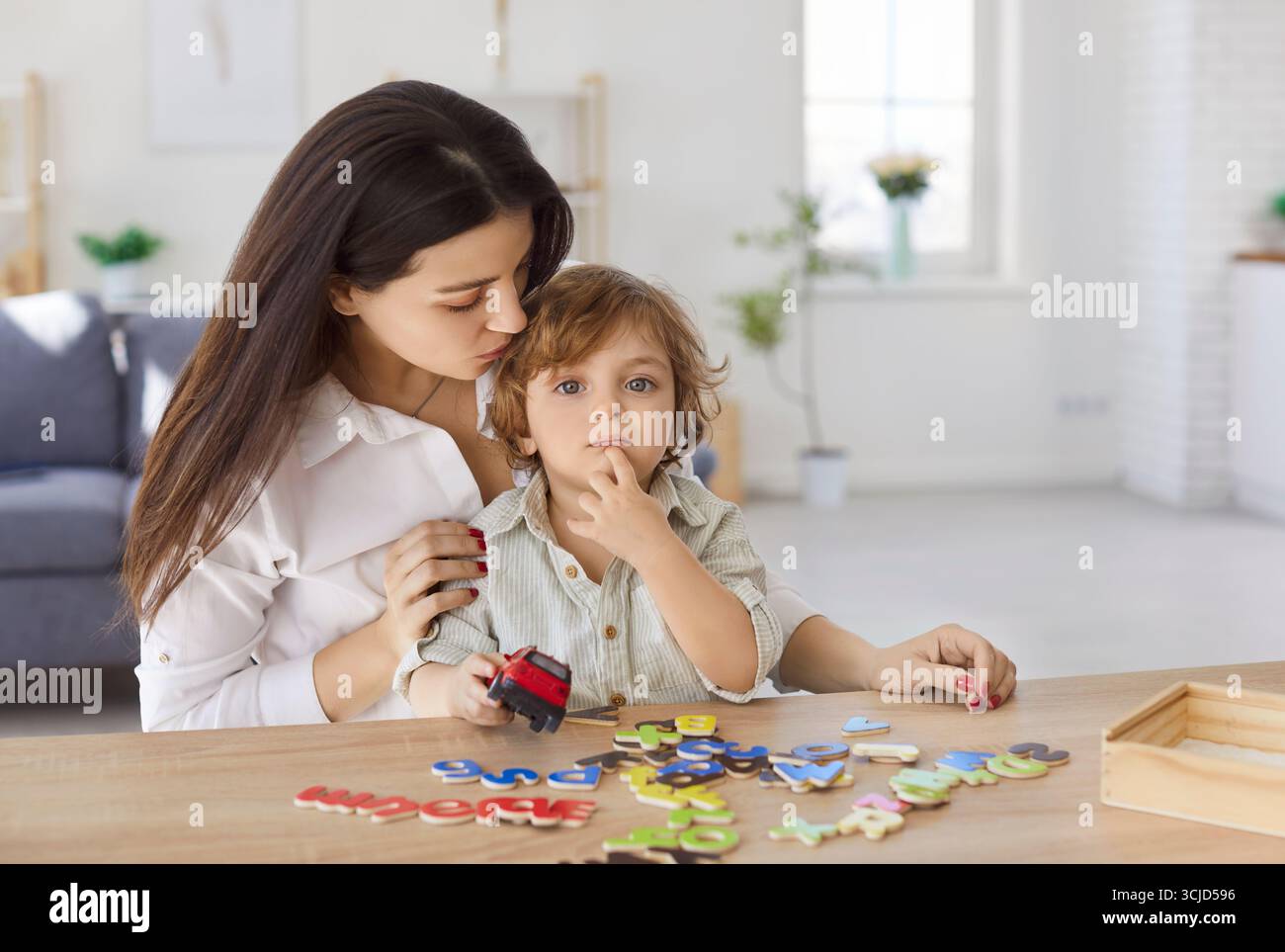 Mother and son playing game with English alphabet letters, mom and boy ...
