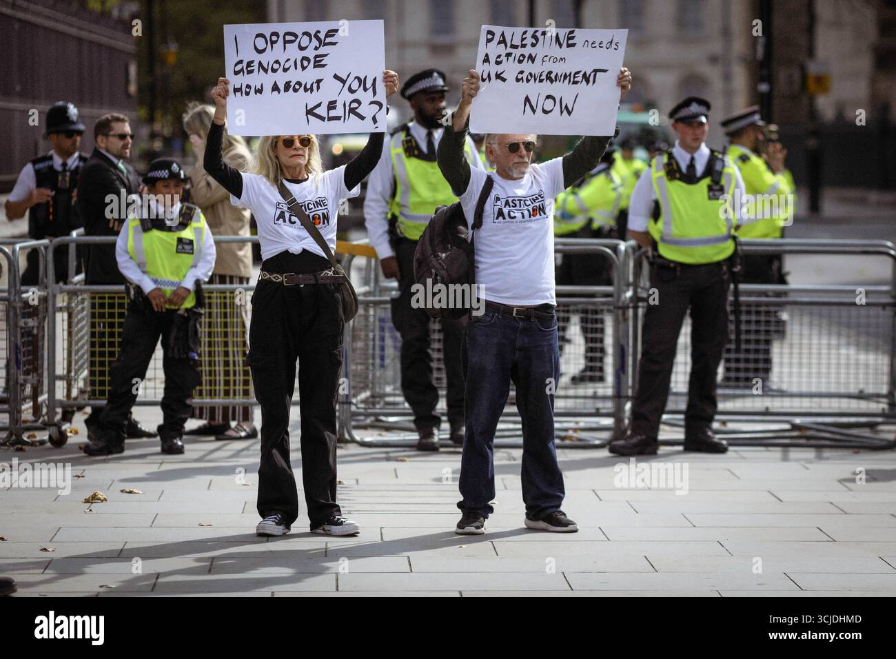 Protesters hold placards in front of the police during the ...