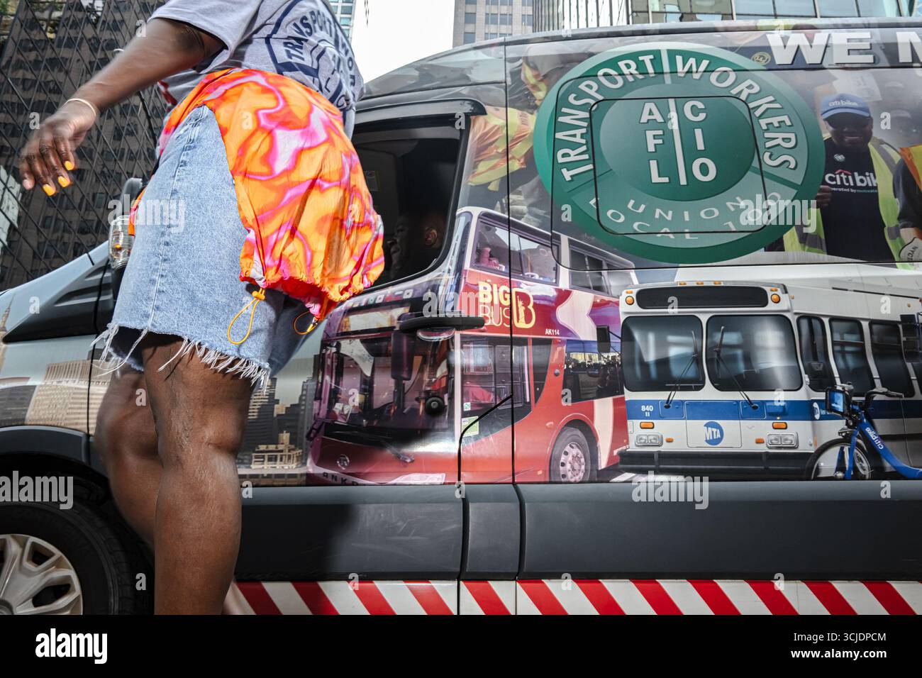 A member of the Transport Workers Union Local 100 walks alongside the ...