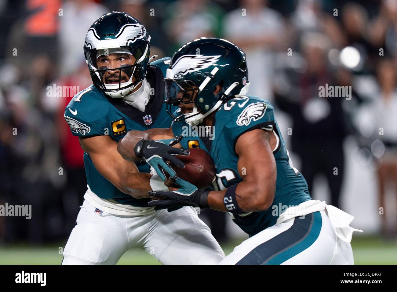 Philadelphia Eagles running back Saquon Barkley, right, takes the hand off from quarterback ...