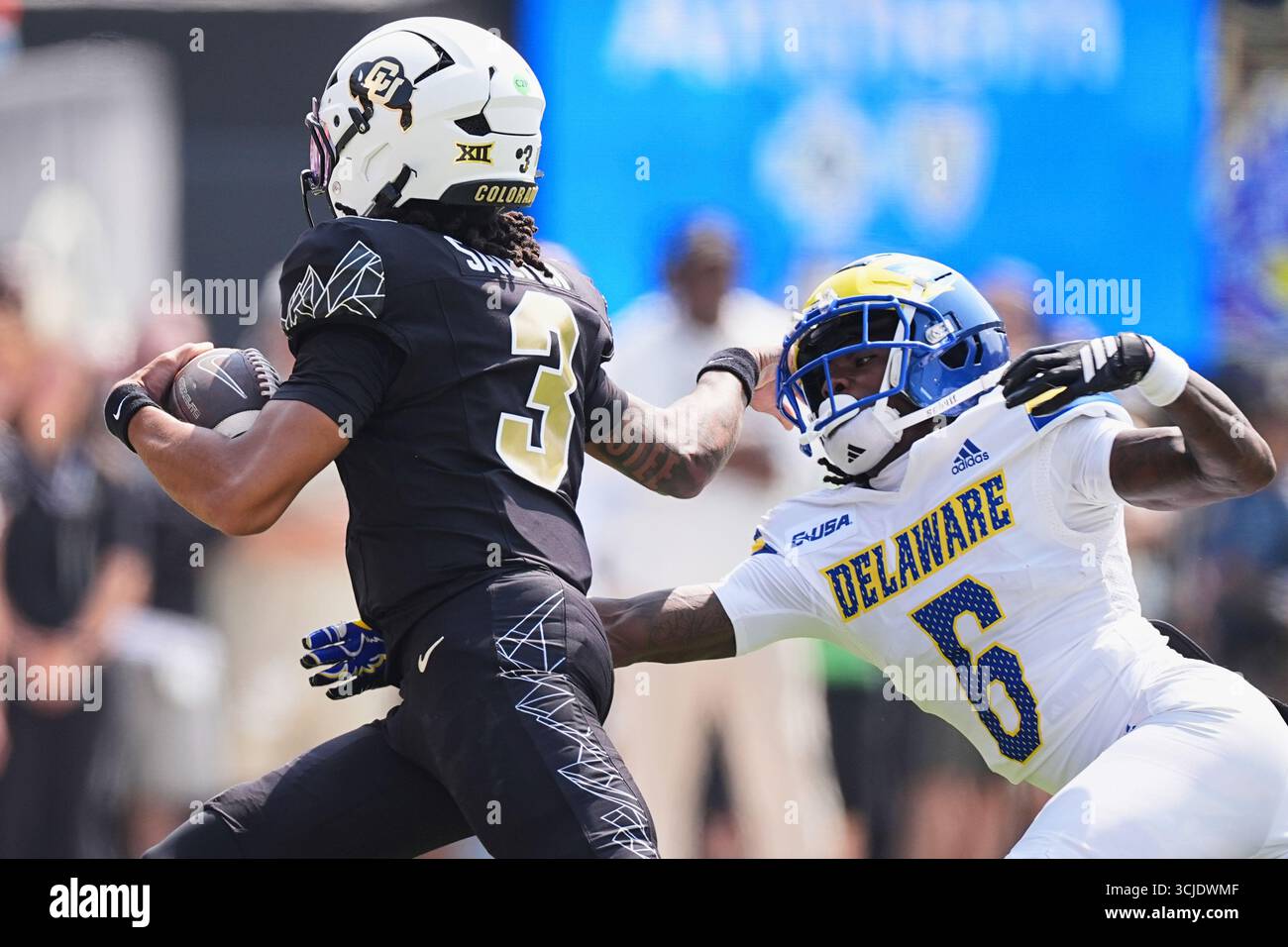 Colorado quarterback Kaidon Salter, left, eludes Delaware cornerback ...