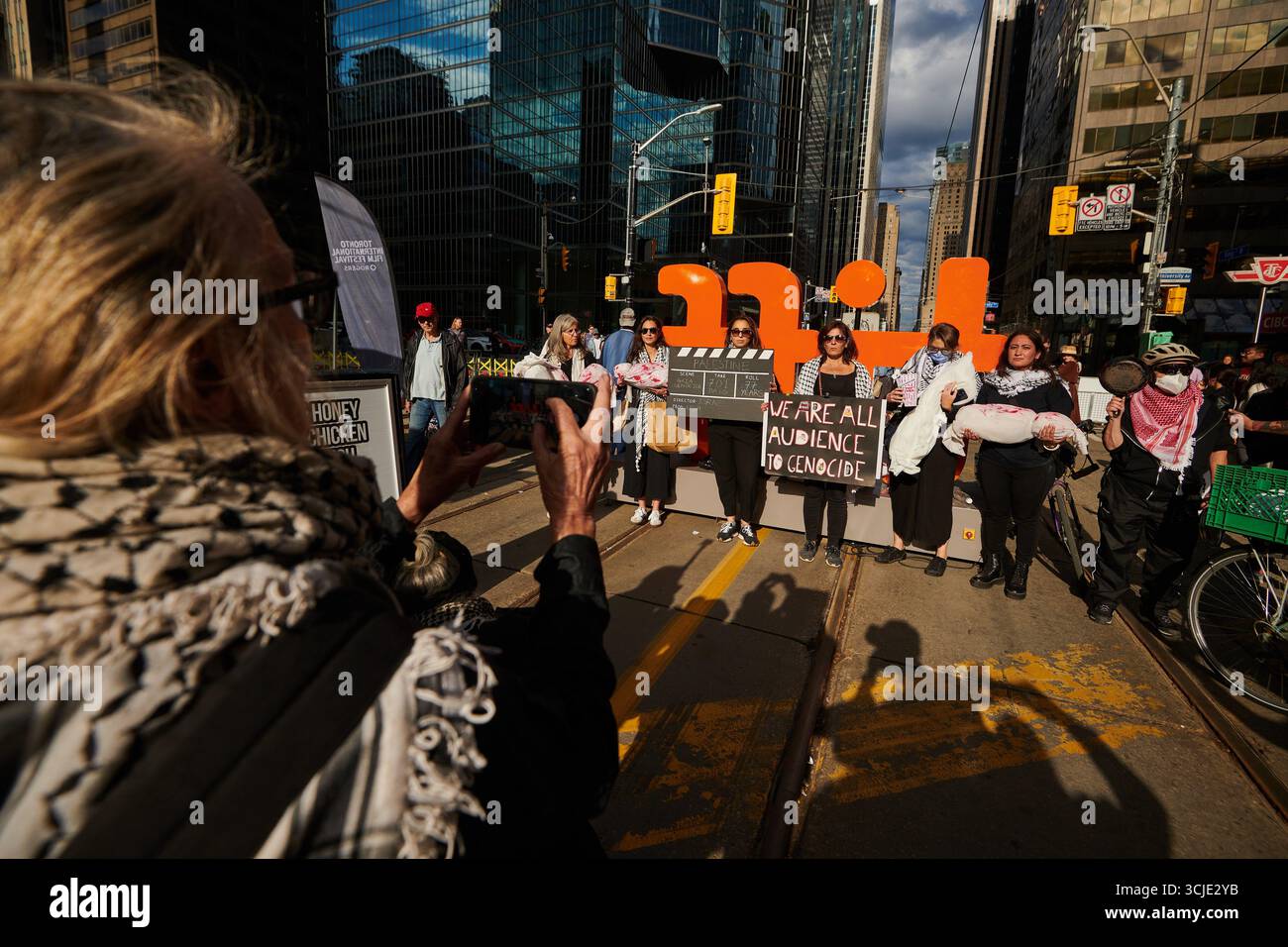 Protesters stand in front of the TIFF entrance sign during the Toronto ...