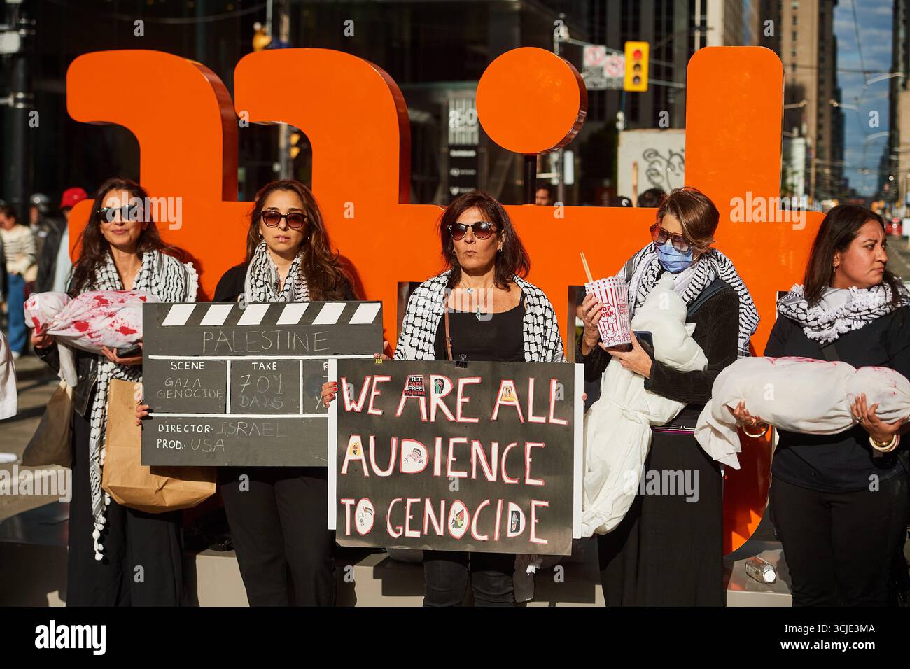 Protesters stand in front of the TIFF entrance sign during the Toronto ...