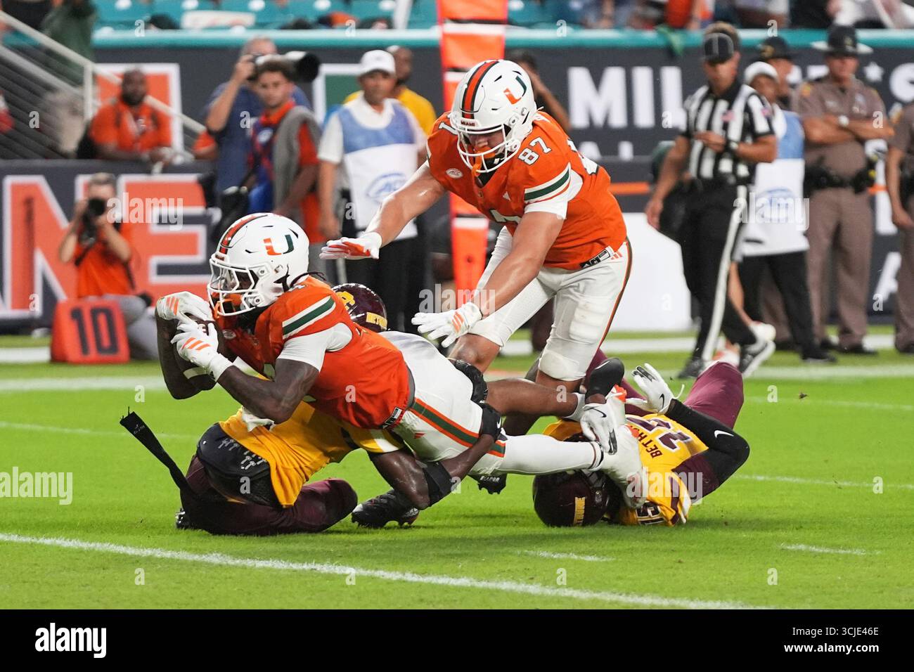 Miami Hurricanes running back Mark Fletcher Jr., center, left, scores a ...