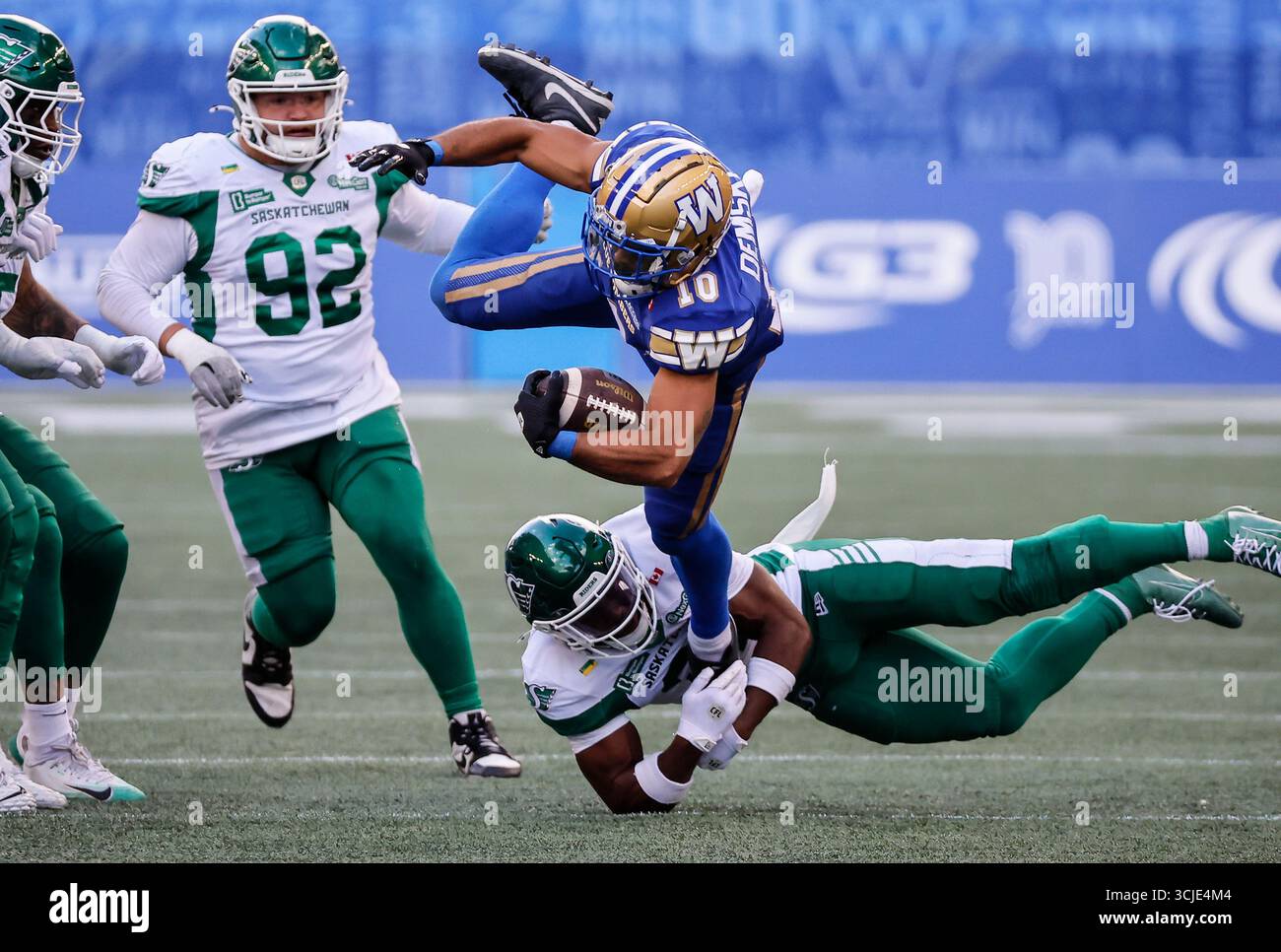 Winnipeg Blue Bombers' Nic Demski (10) leaps over Saskatchewan Roughriders' Kosi Onyeka (31) for ...