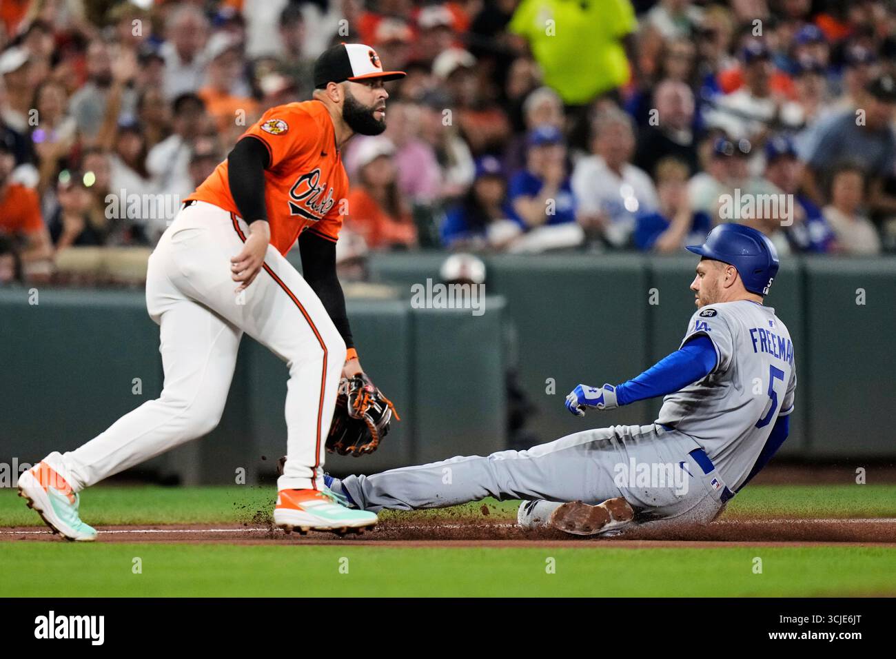 Los Angeles Dodgers' Freddie Freeman (5) slides into third base past ...