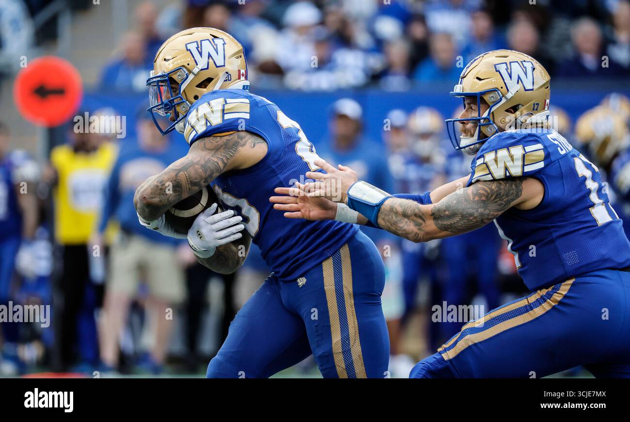 Winnipeg Blue Bombers quarterback Chris Streveler (17) hands off to Brady Oliveira (20) during ...