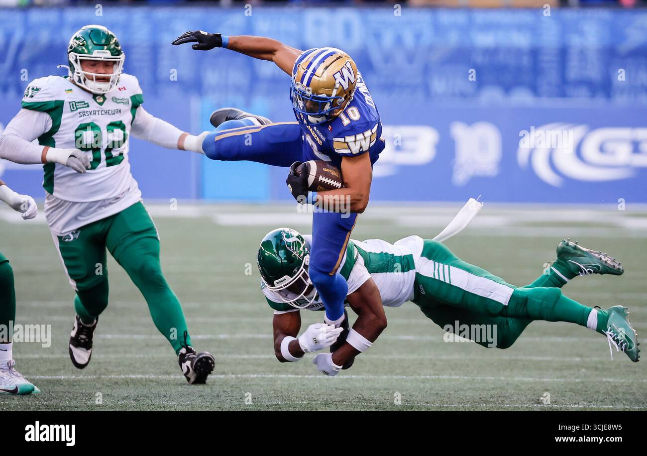 Winnipeg Blue Bombers' Nic Demski (10) leaps over Saskatchewan Roughriders' Kosi Onyeka (31) for ...