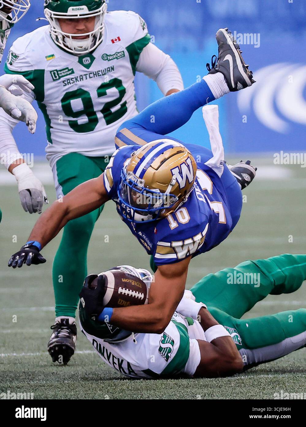 Winnipeg Blue Bombers' Nic Demski (10) leaps over Saskatchewan Roughriders' Kosi Onyeka (31) for ...