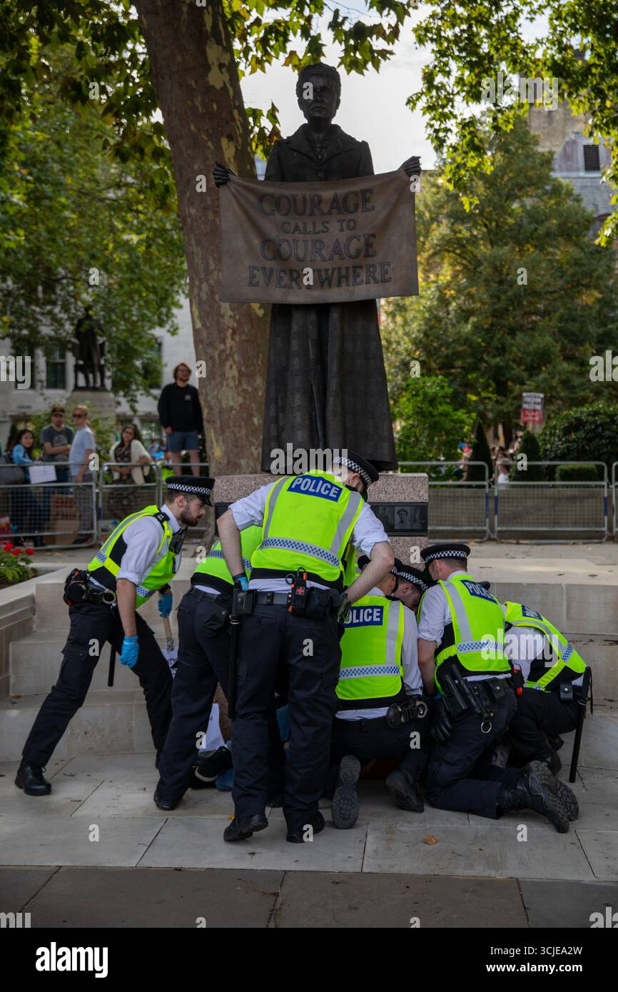 Police officers arrest a Palestine Action supporter during a ...