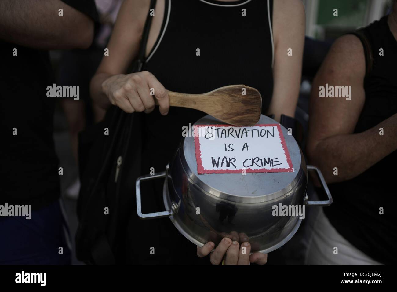 FILE - An Israeli activist bangs a pot with a wooden spoon to protest ...