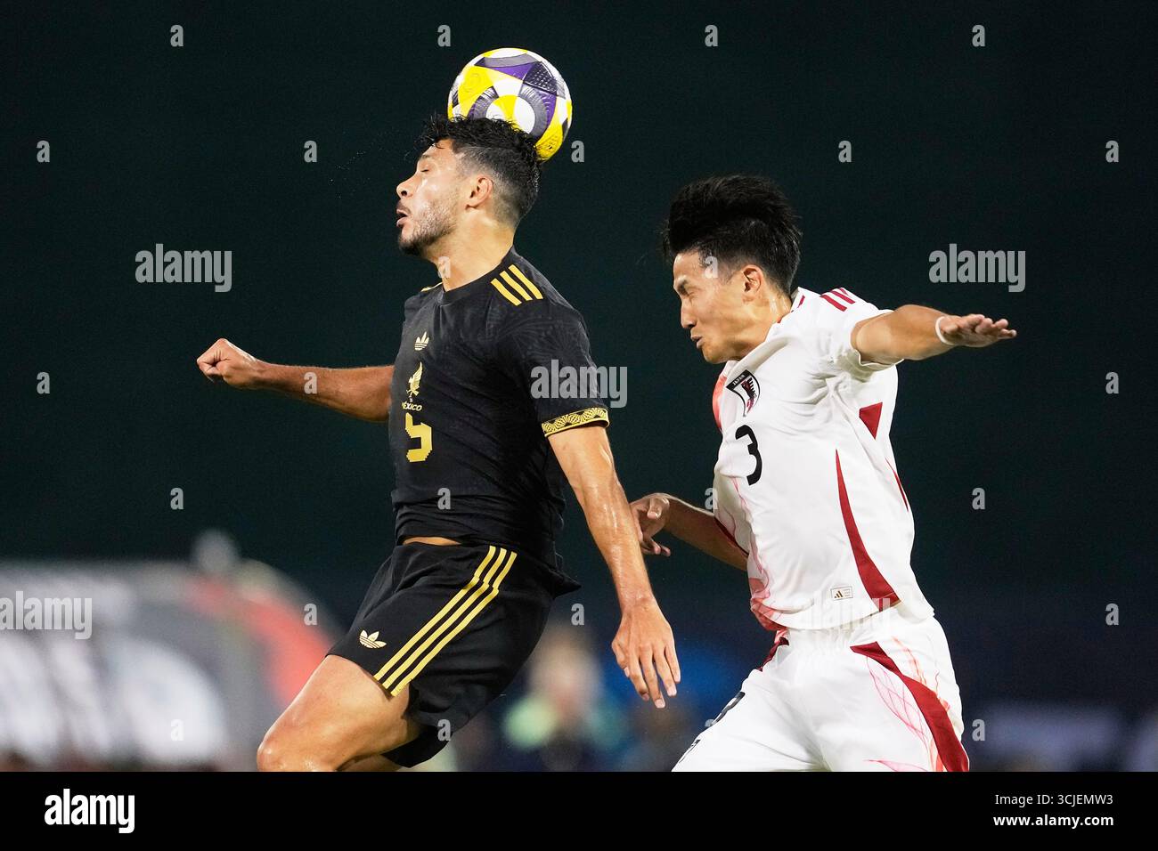 Mexico's Raúl Jiménez, left, goes for the ball against Japan's Tsuyoshi ...