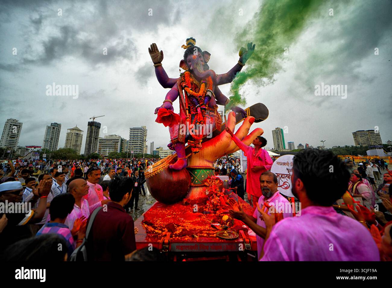 Devotees seen throwing colorful powder to an idol of Lord Ganesh during ...