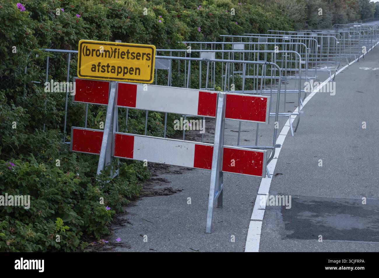 Red and white crowd control barriers blocking a road, with a yellow ...