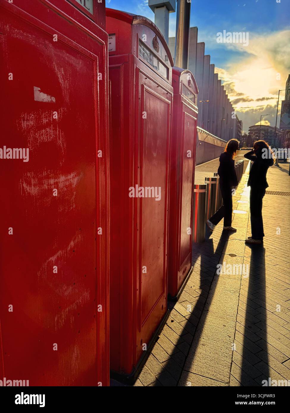 K2 traditional red telephone boxes and two people casting long shadows ...