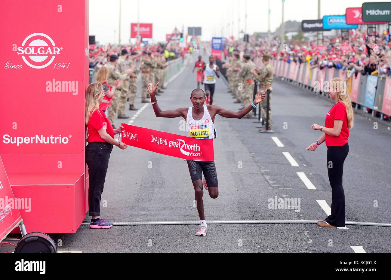 Alex Mutiso crosses the finish line in first place to win the Elite ...