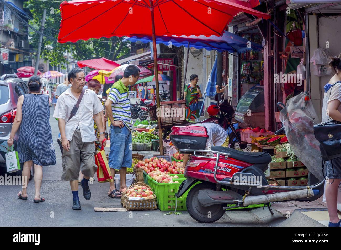 CHENGDU, CHINA - JUNE 20: People buying and selling fruits and ...