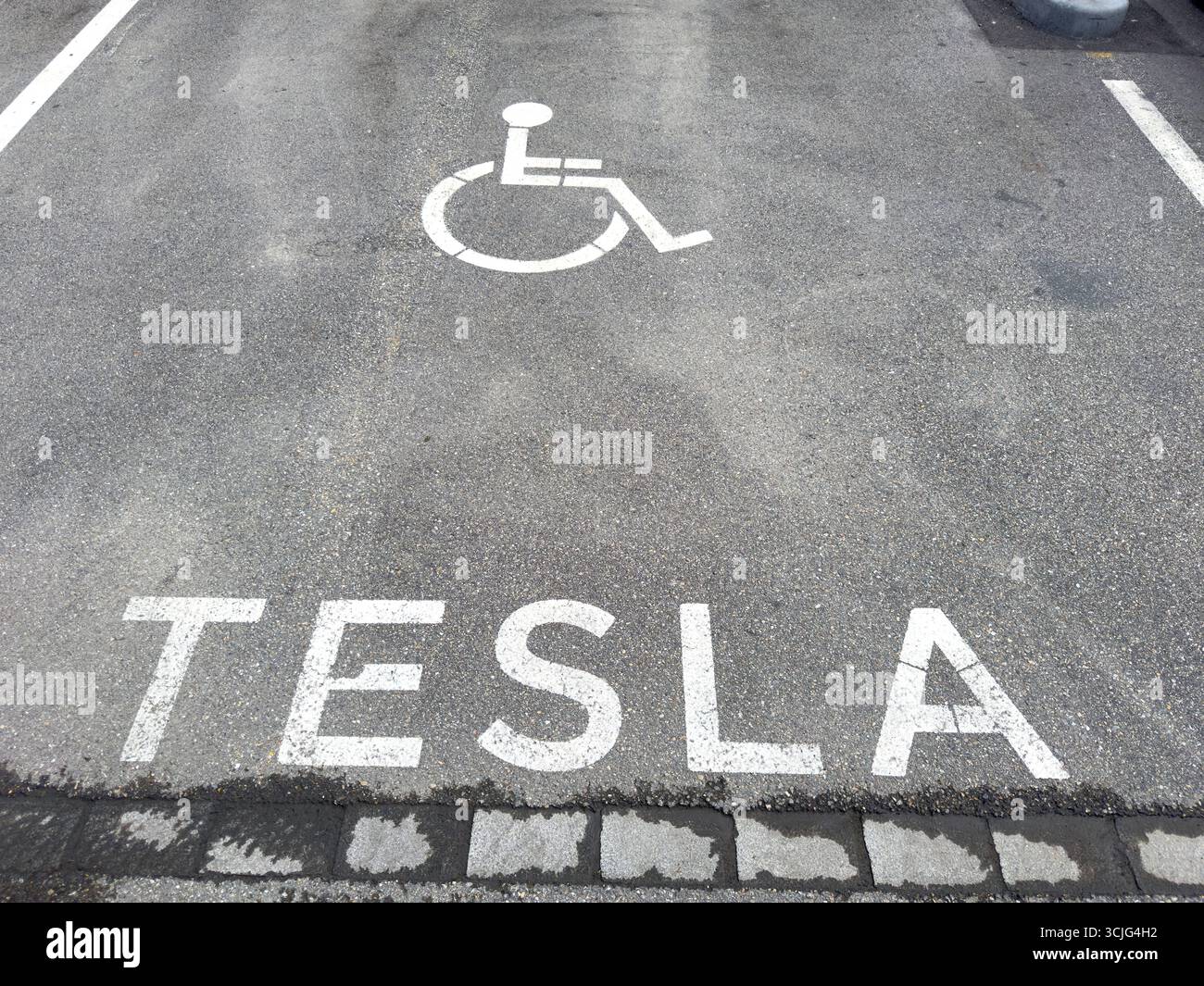 Sign for handicaped persons on the ground at a Tesla Super Charger ...