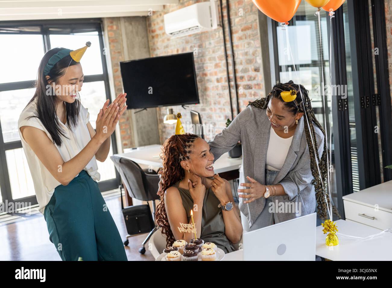 Celebrating birthday in office, colleagues wearing party hats and ...