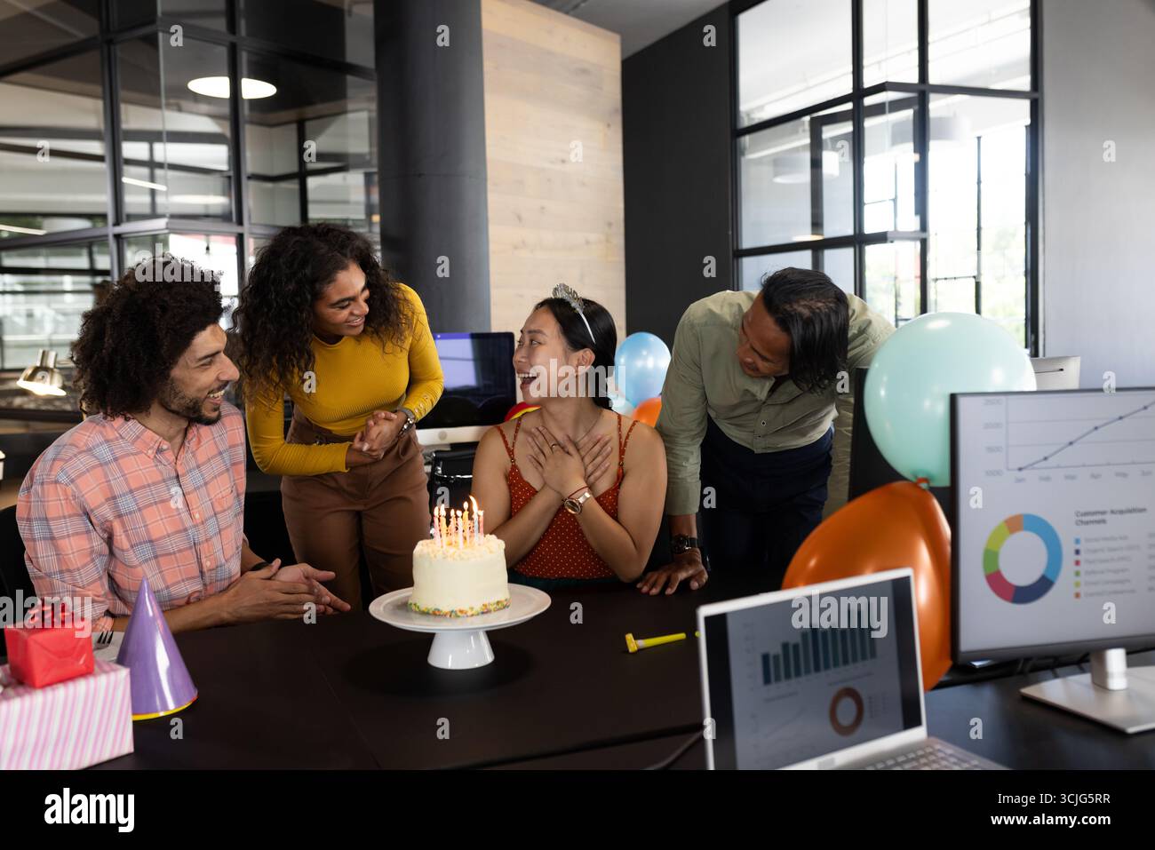 Celebrating birthday, colleagues sharing cake and balloons in office ...