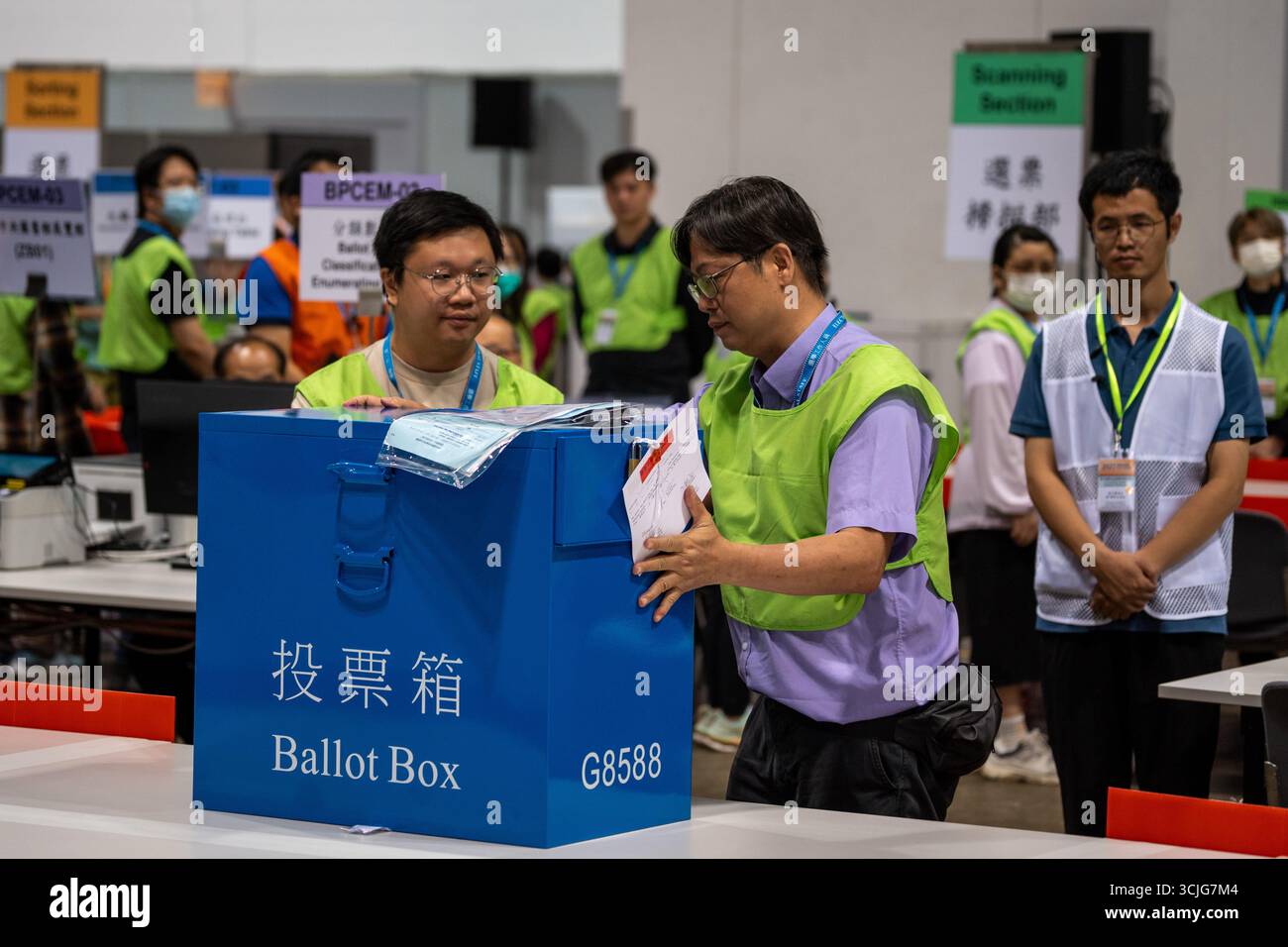 Voting station workers putting a ballot box on the table at the ballot ...