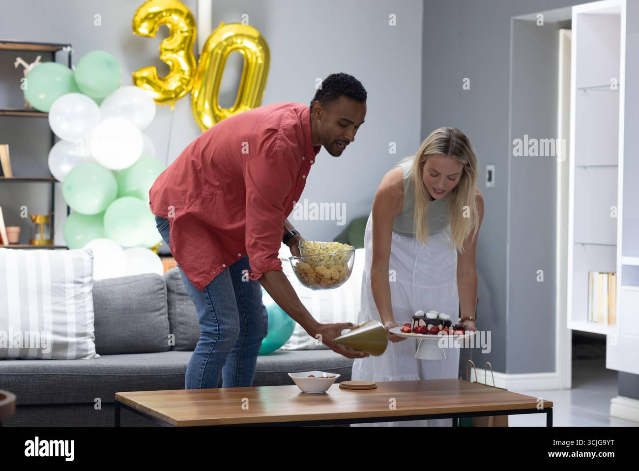 Celebrating home couple arranging snacks hi-res stock photography and ...
