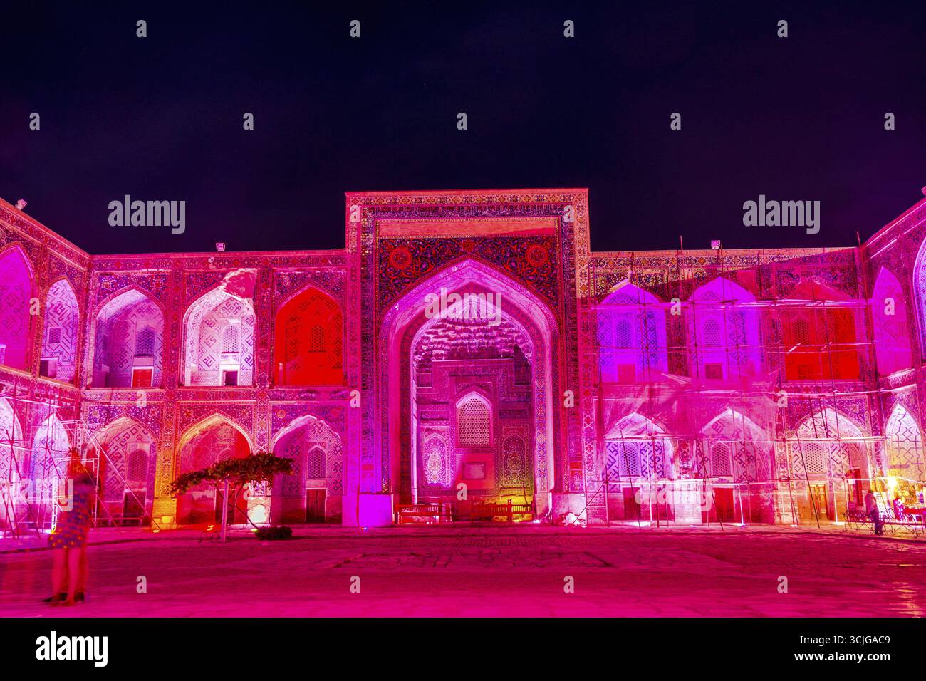 Illuminated atrium of Sher Dor madrasah at night, Registan, Samarkand ...