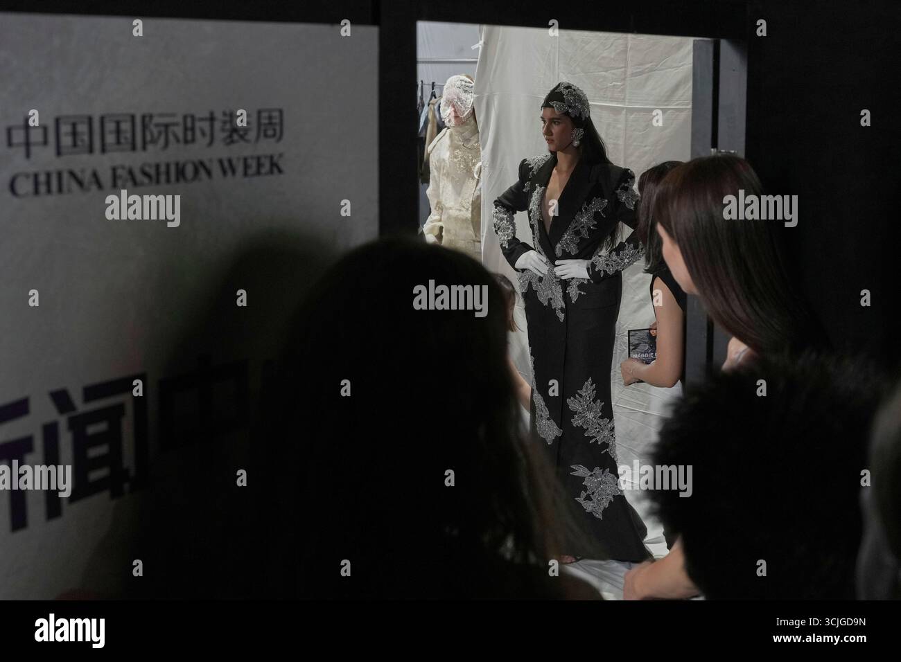 Models stand at a doorway as they try on creations by Maggie Ma in the ...