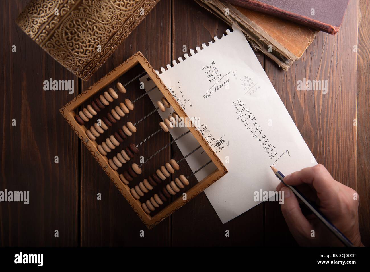 Traditional wooden abacus with beads placed on a dark wooden surface ...